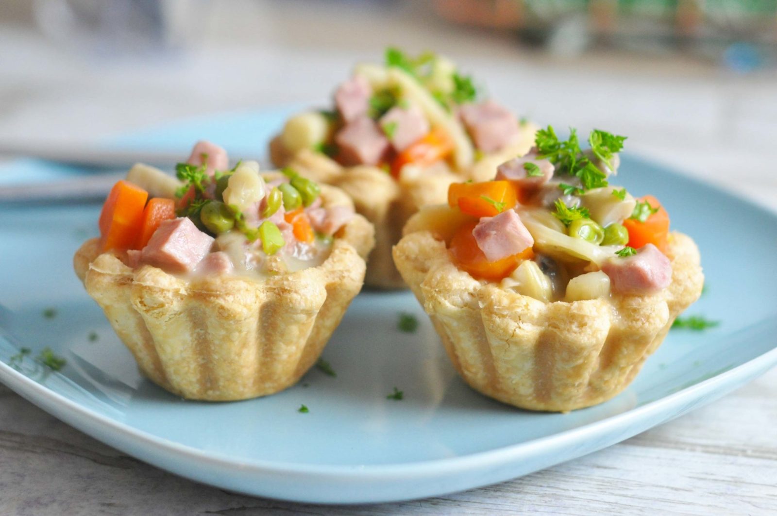 Crispy tartlets with ham, white asparagus and peas