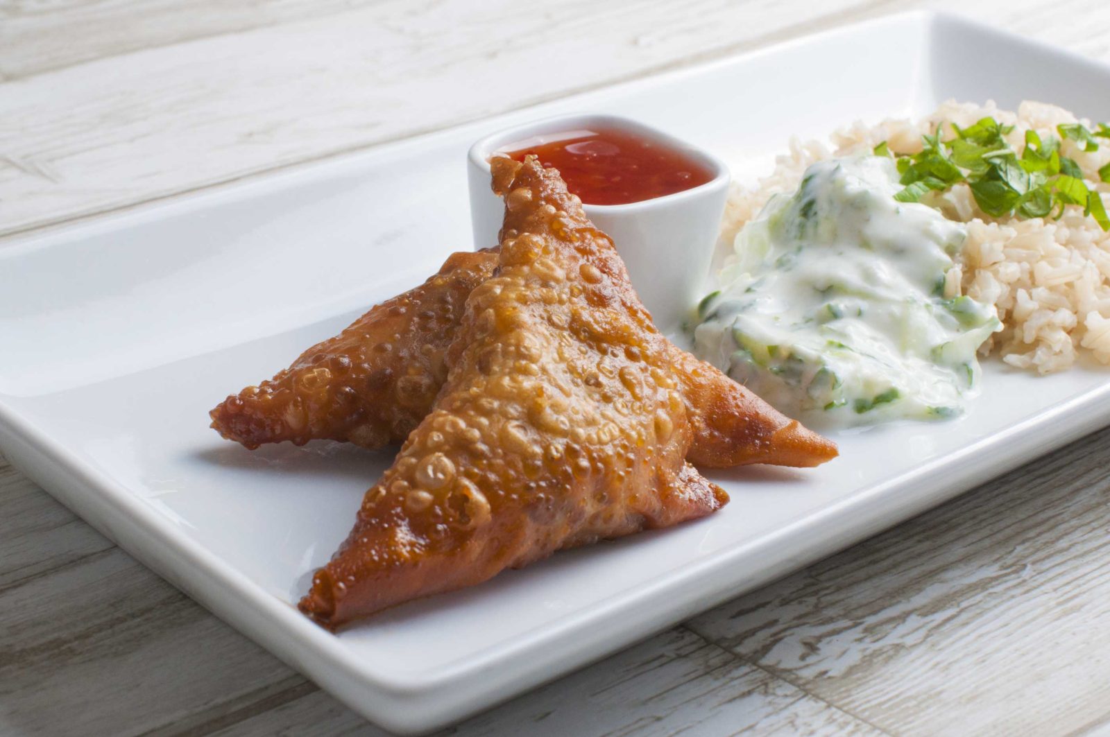 Crispy samosas with beef filling - served with raita and rice
