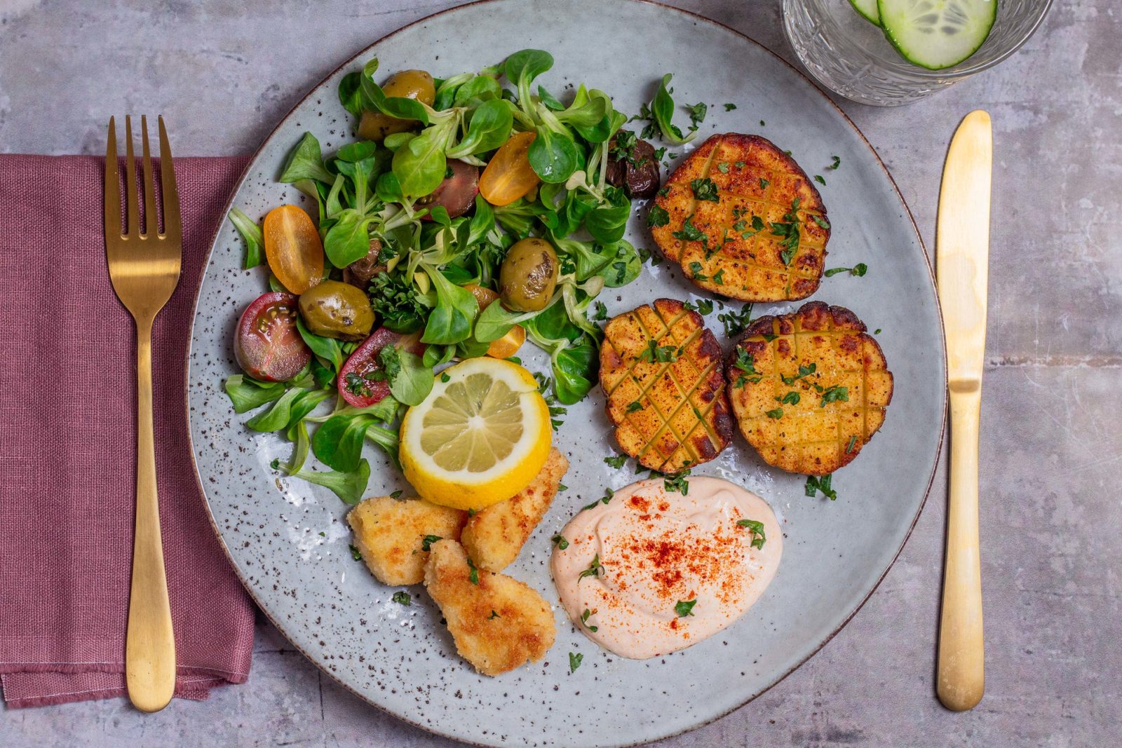 Cod bites with scored potatoes, salad and tartar sauce