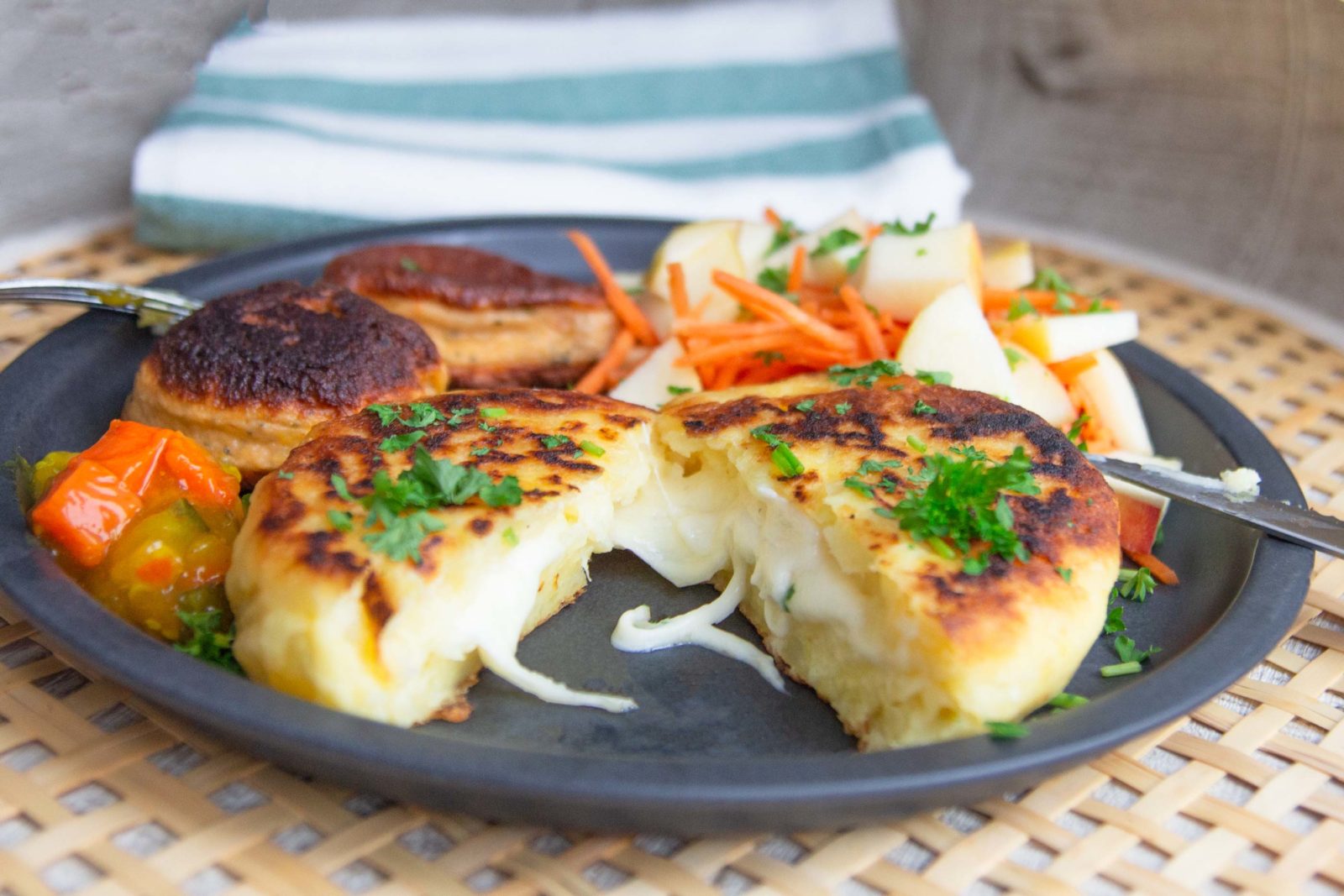 Fishcakes with cheese-stuffed potato cakes and fruit salad