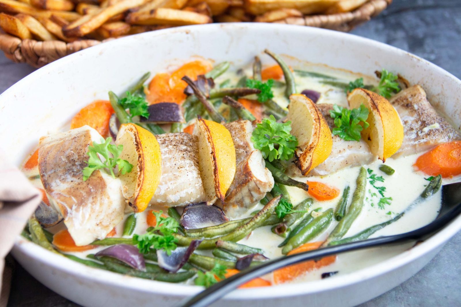 Pollock fillets on bed of veggies with creamy sauce